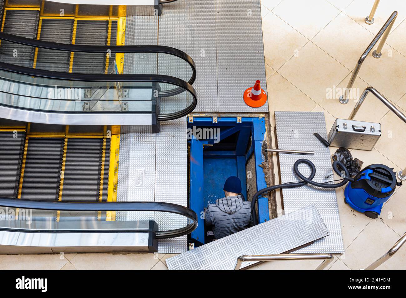 Moscow, Russia - April 04, 2022: worker repairing escalator mechanism ...