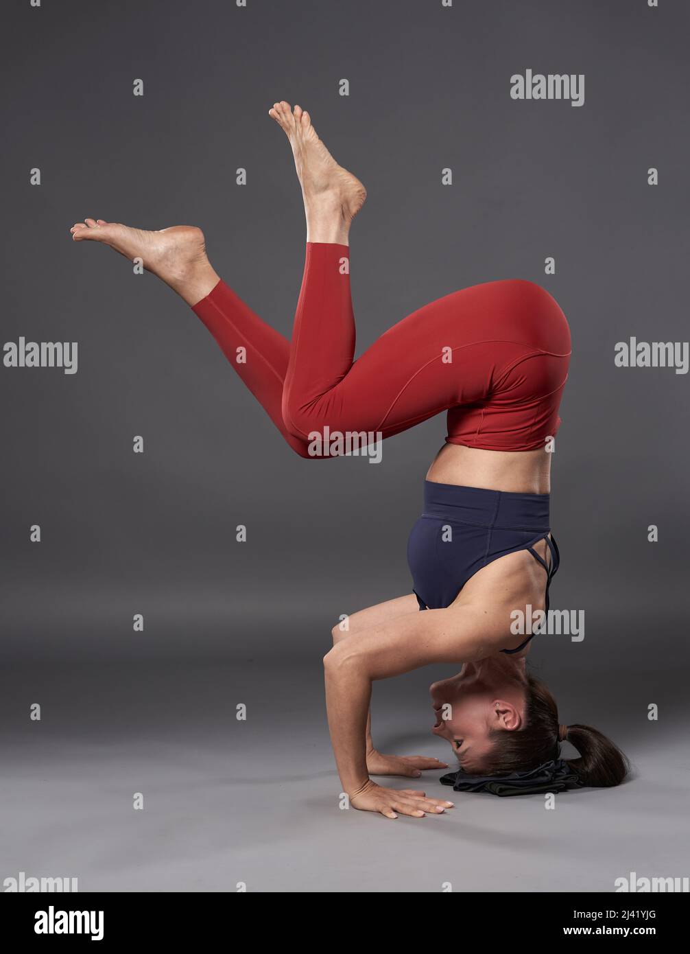 Woman Yoga practitioner doing Sirsasana (head stand) pose Stock Photo ...