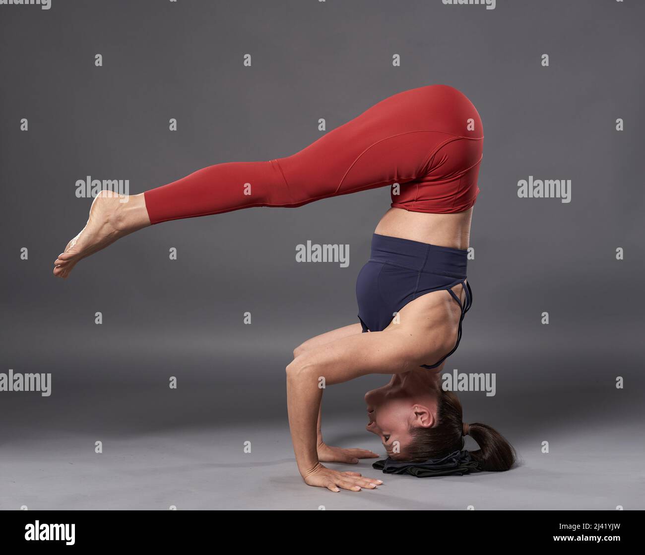 Woman Yoga practitioner doing Sirsasana (head stand) pose Stock Photo ...