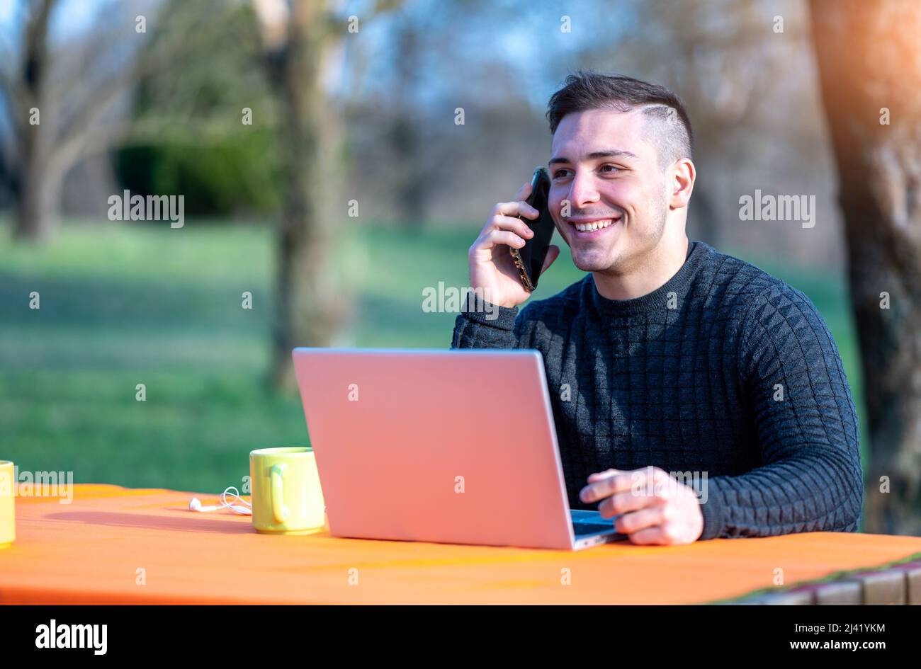 Man on laptop answers cell hi-res stock photography and images - Alamy