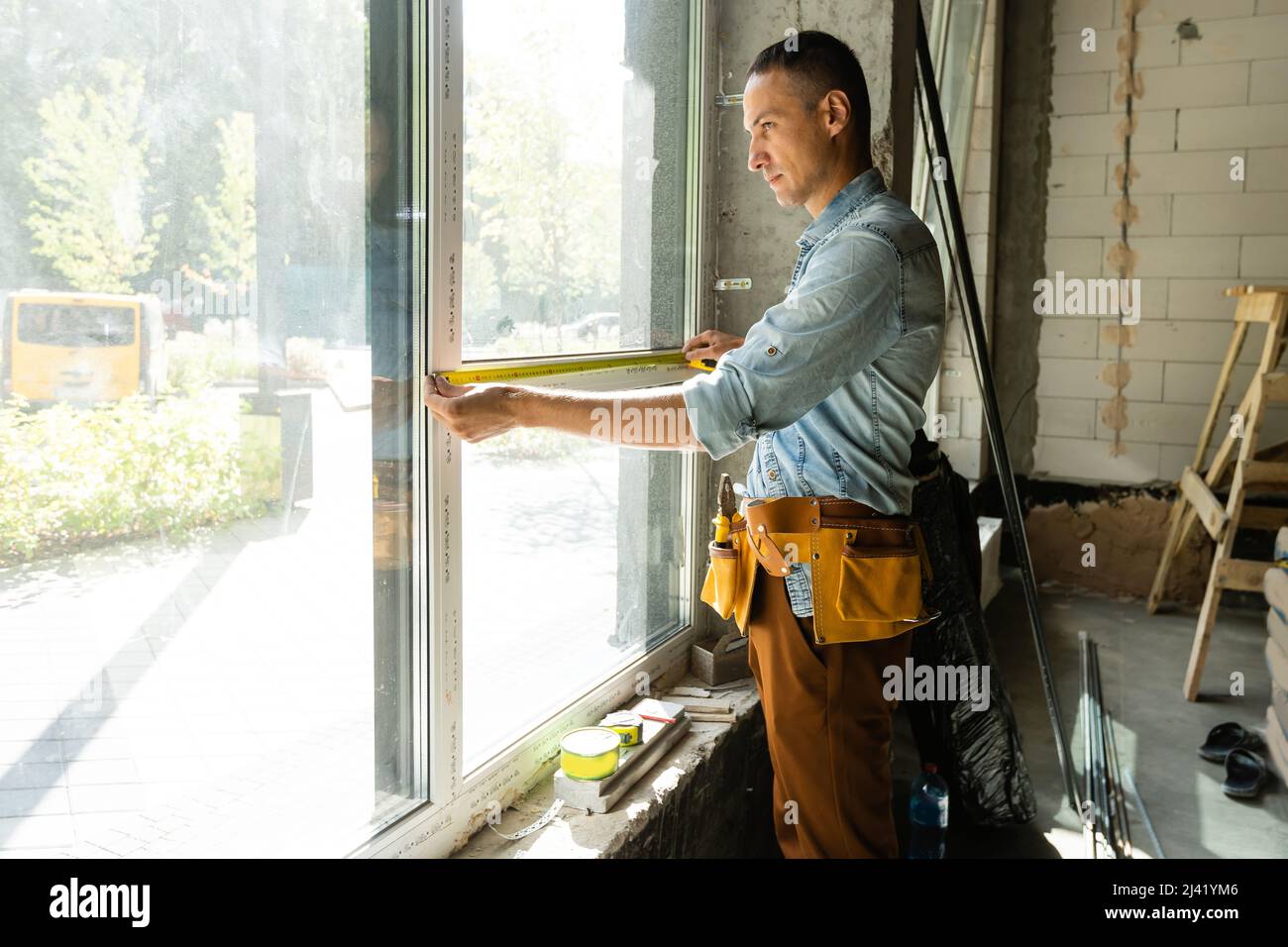 Construction worker installing window in house Stock Photo - Alamy