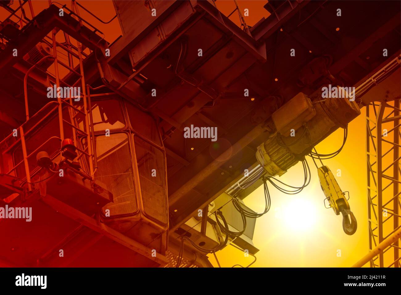 Industrial crane with sun in the background Stock Photo - Alamy