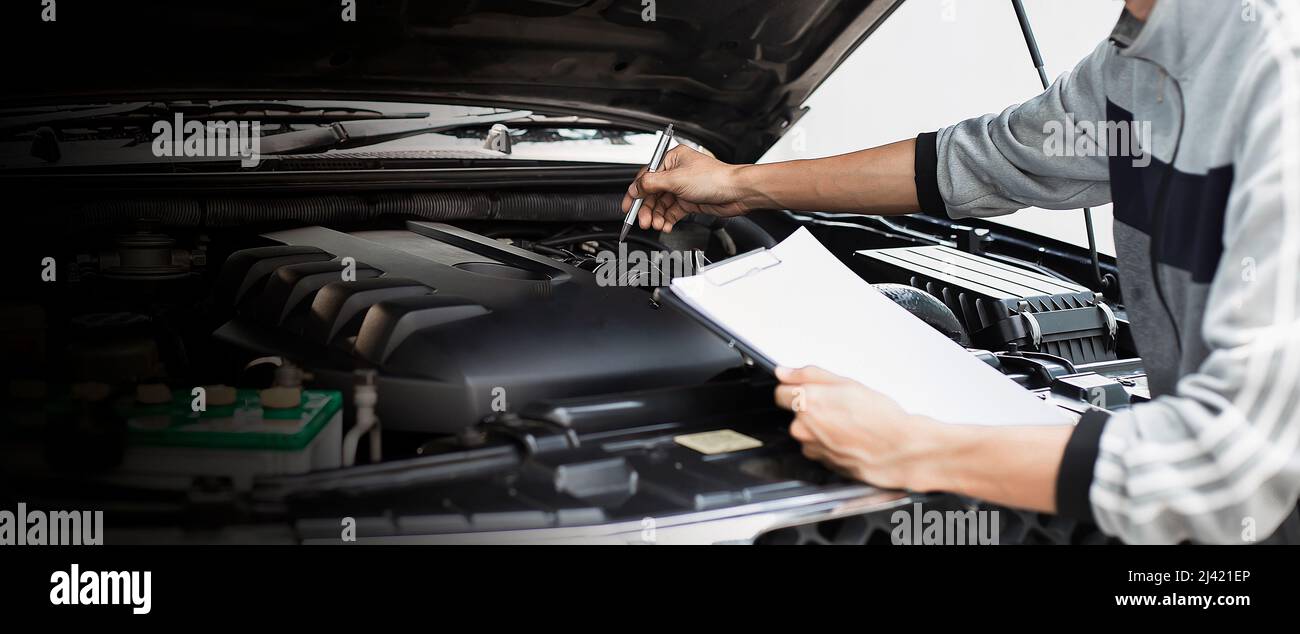 Auto mechanic checking the engine of a car service car,and maintenance ...