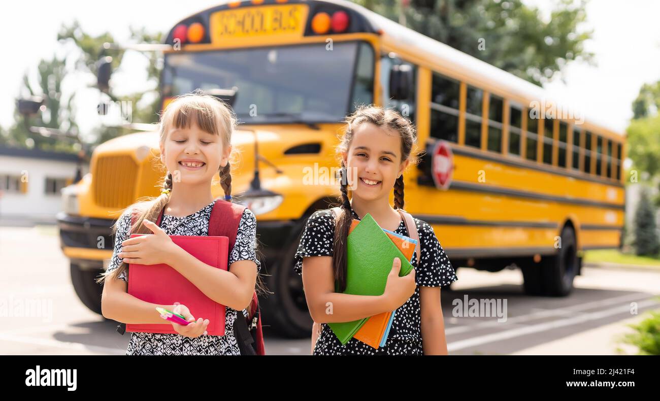 Education: Smiling Student Friends Ready For School next to school bus ...