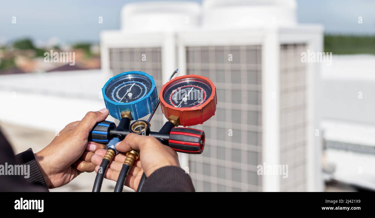Air conditioner technician checks the operation of industrial air ...