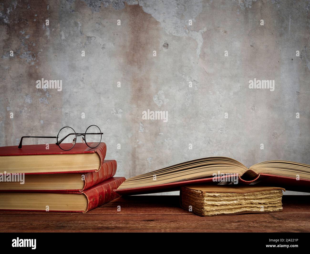 antique books and reading glasses on a rustic wooden table with a ...