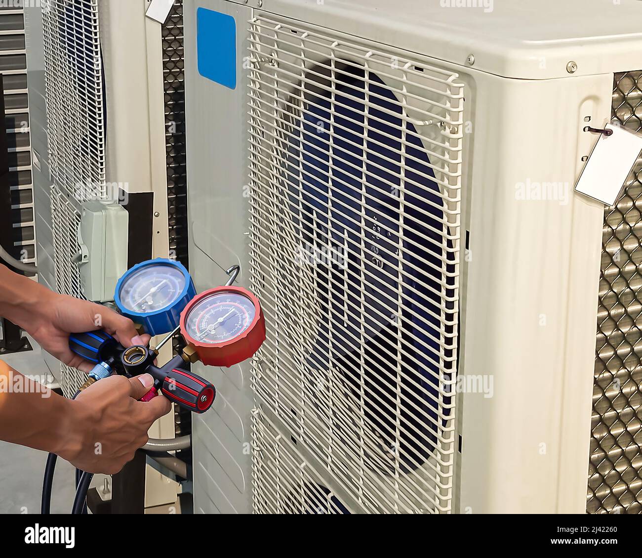 Air conditioner technician checks the operation of industrial air ...