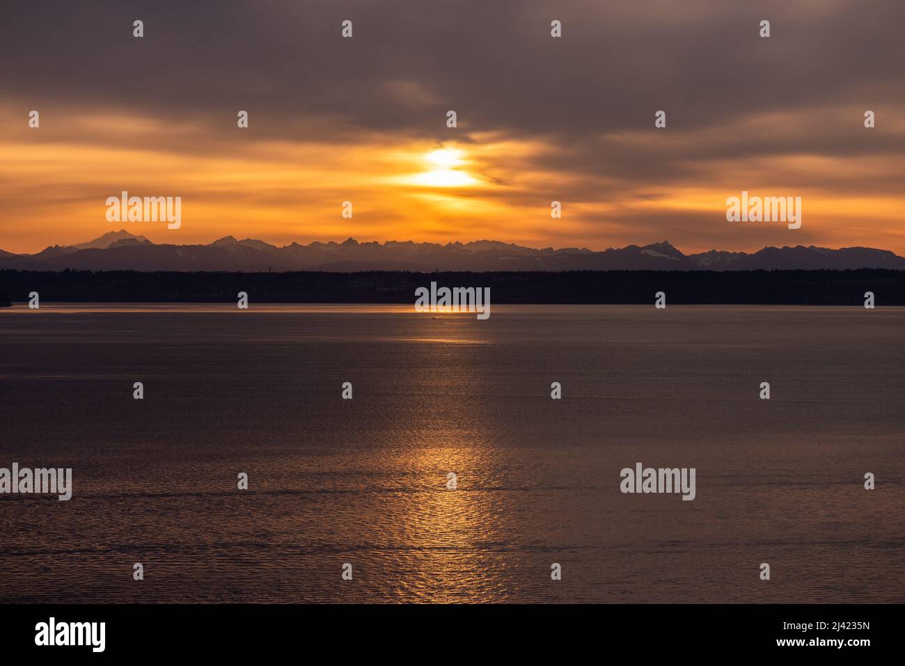 Golden hour sunset over scenic Olympic mountains and Puget Sound bay of ...