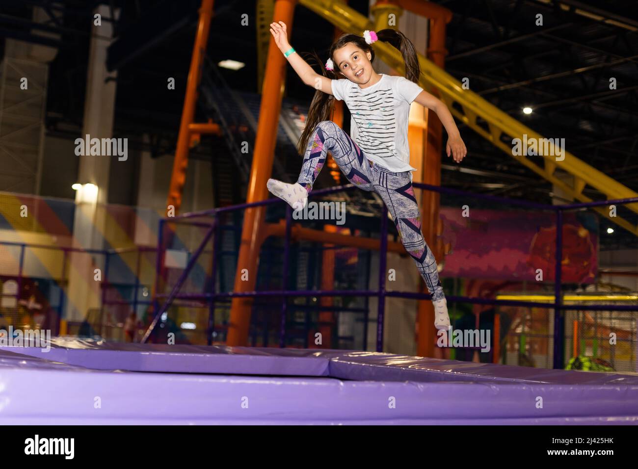 Little child jumping at trampoline in indoors playground. Active ...