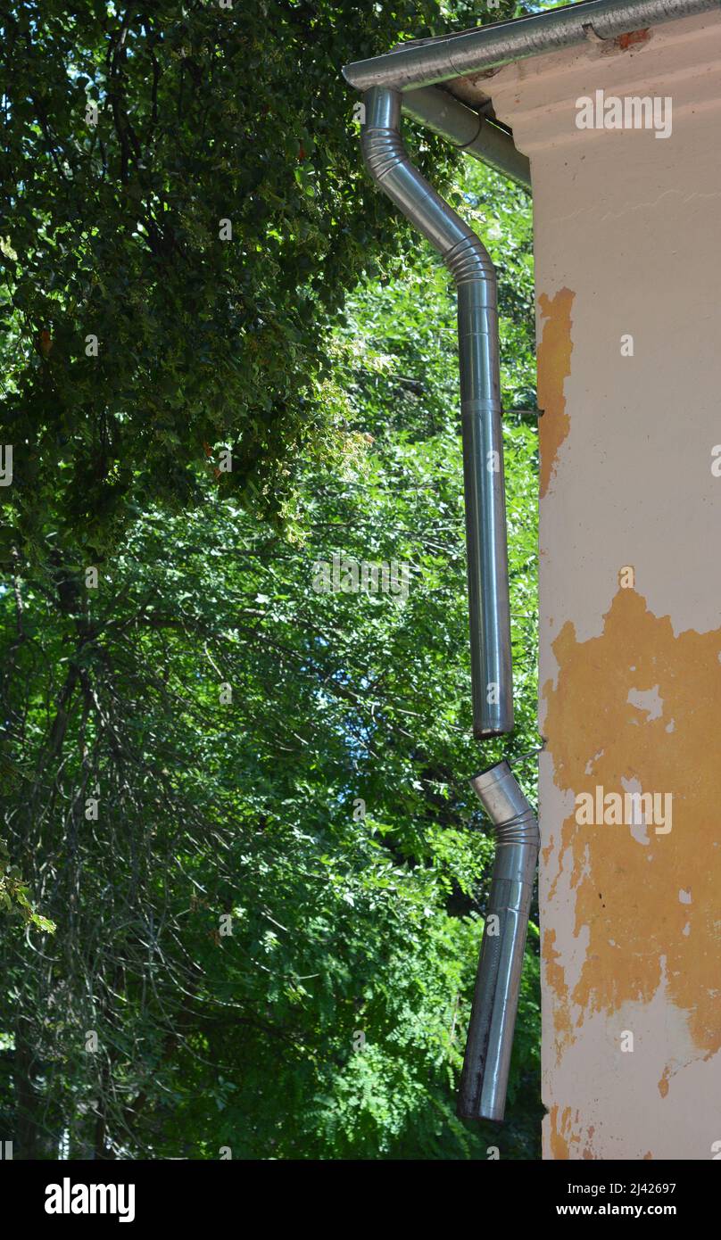 Roof gutter problems and damages. A close-up of a broken roof gutter ...