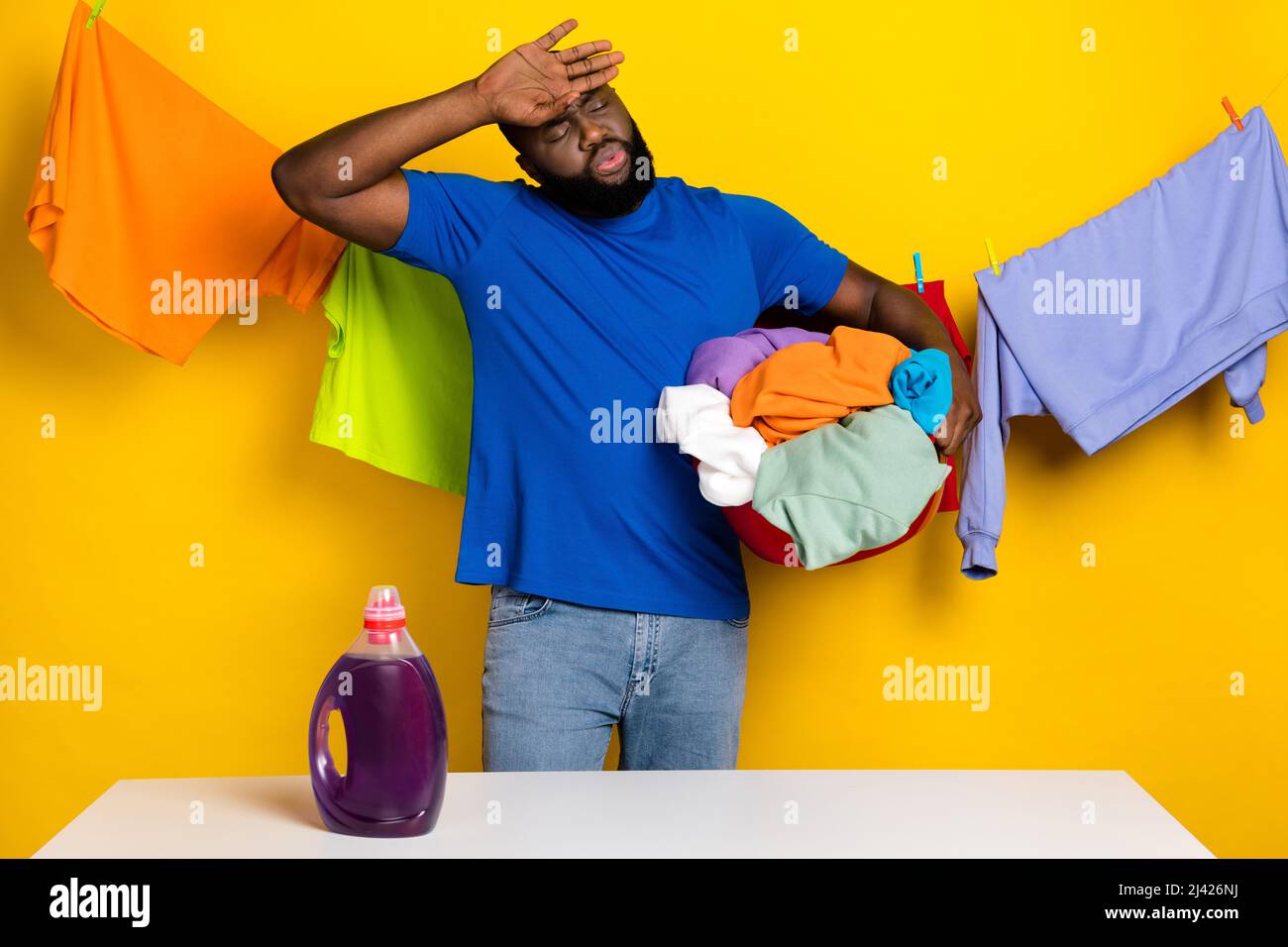 Portrait of handsome trendy exhausted guy hand washing linen in bowl ...