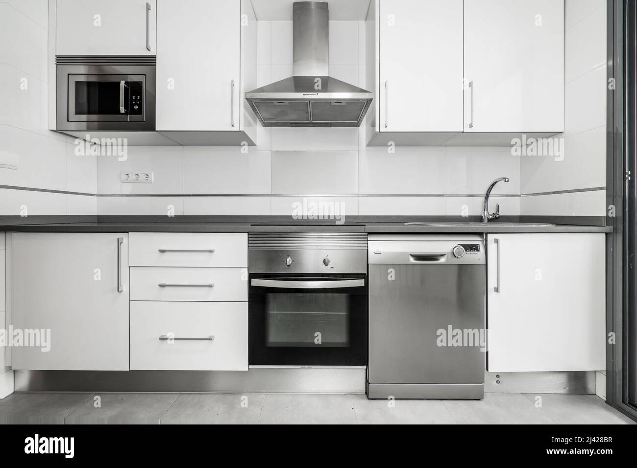 Front view of kitchen with white wood cabinets with gray counter tops ...