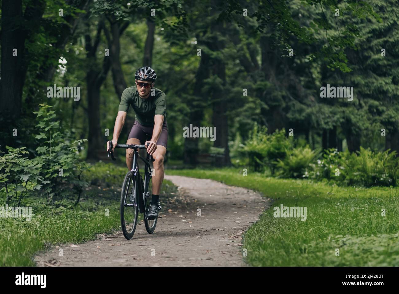 Healthy and active cyclist in safety helmet and mirrored glasses riding ...