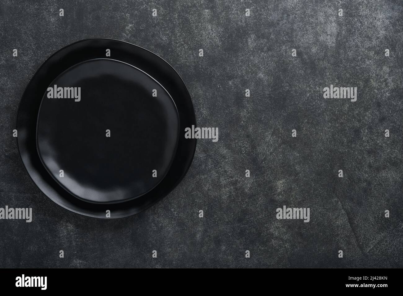 Ceramic empty black plate on old black ceramic cement concrete table ...