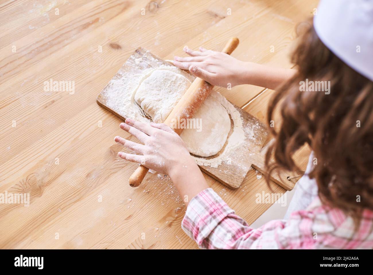 Young girl cooking at kitchen. Curly pretty child portrait. Chef ...