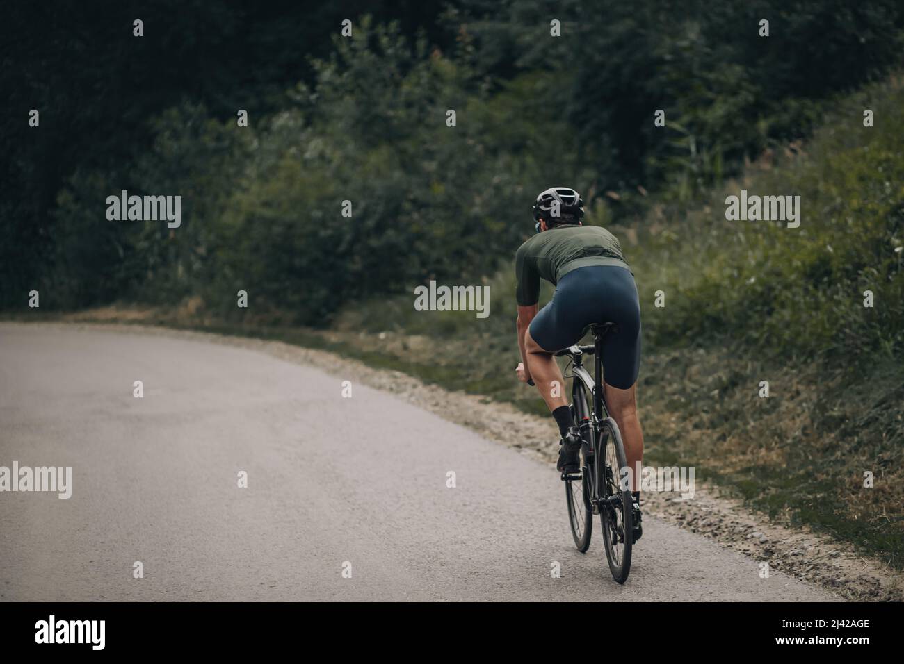 Back view of male athlete in sport clothes and safety helmet riding ...