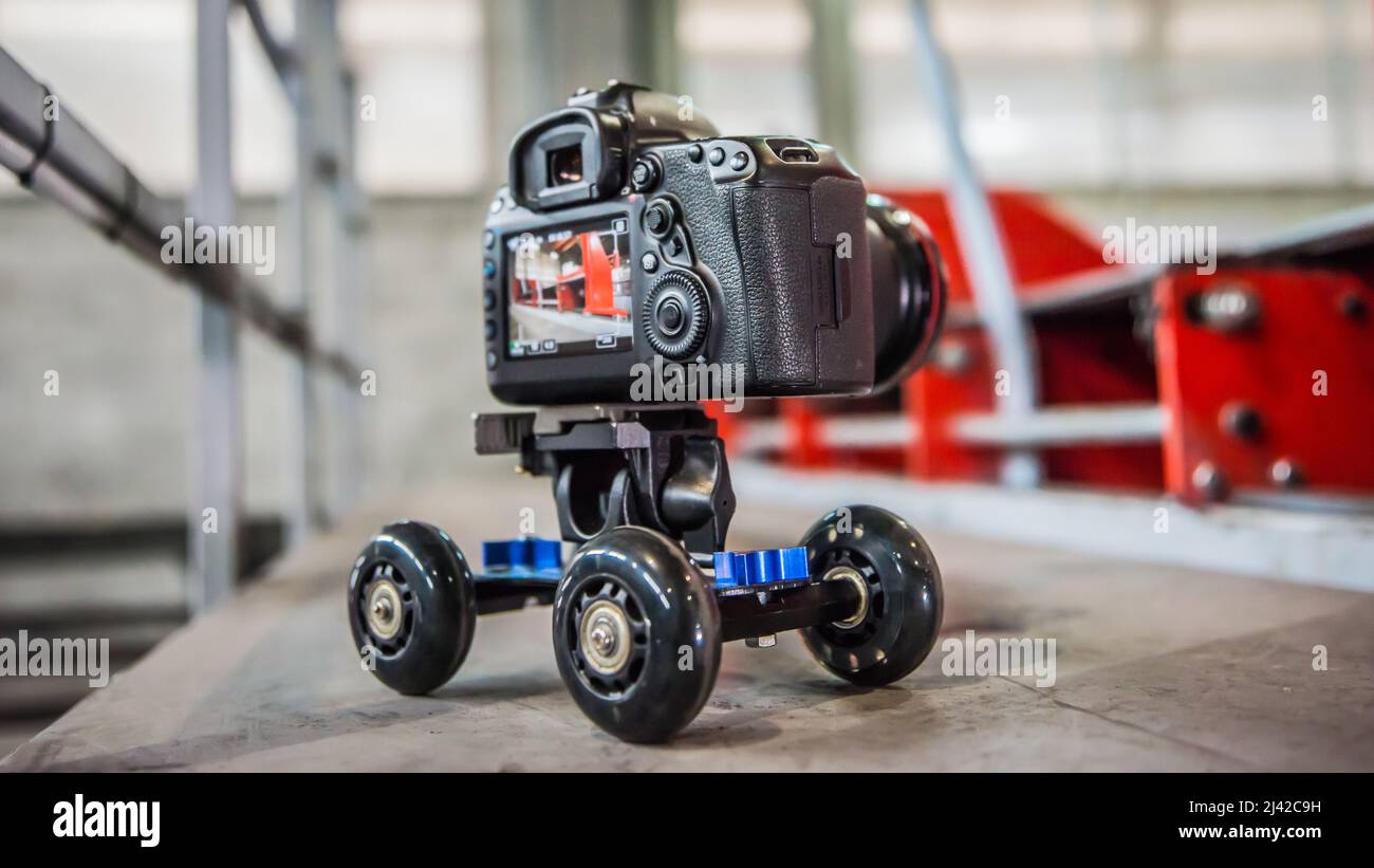 DSLR camera with monitor on mini table desktop rail wheel system making ...