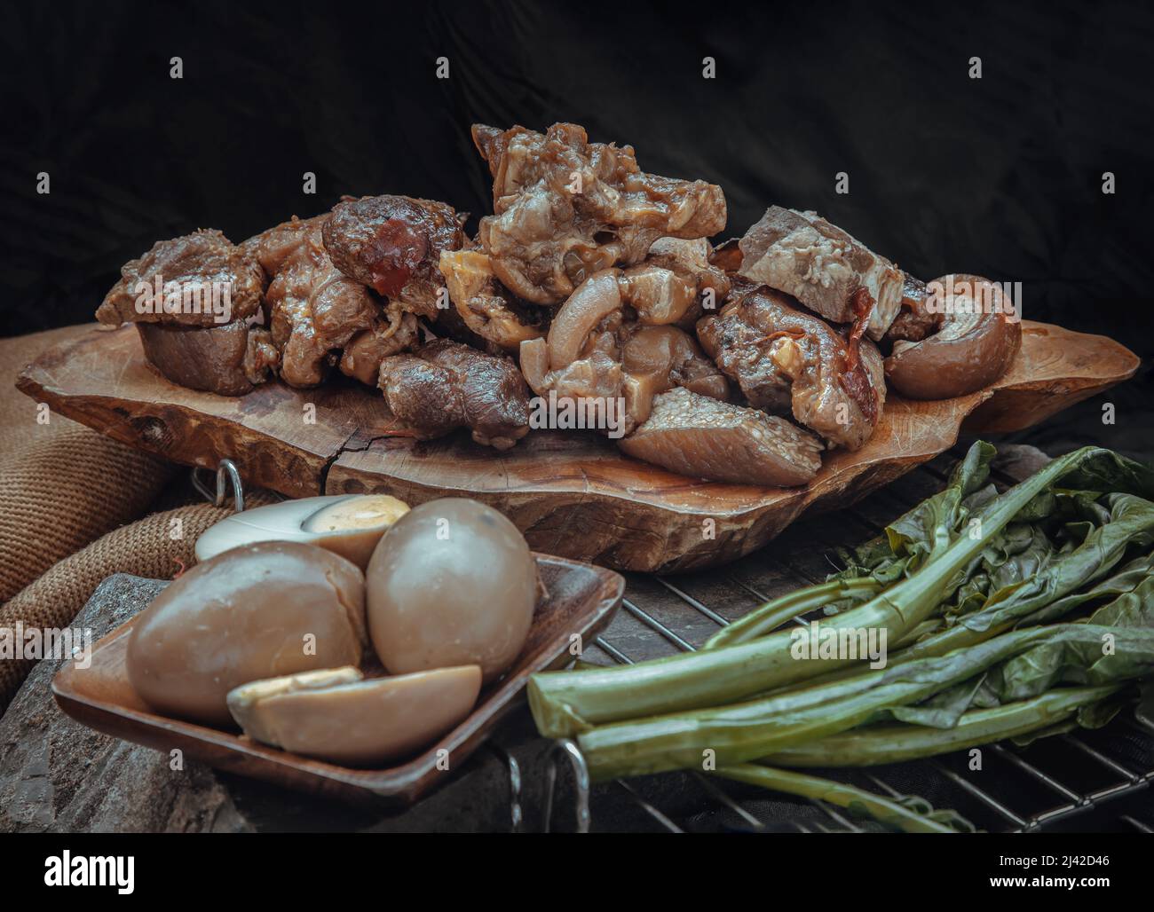 Stewed pork leg, Boiled eggs with Kale on dark background. Selective ...
