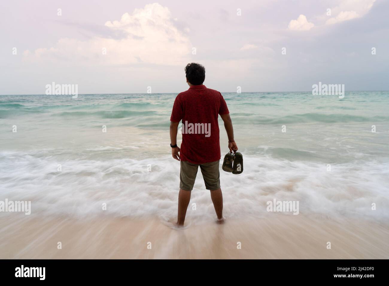 Long exposure shot of person holding up slippers dripping sea water ...