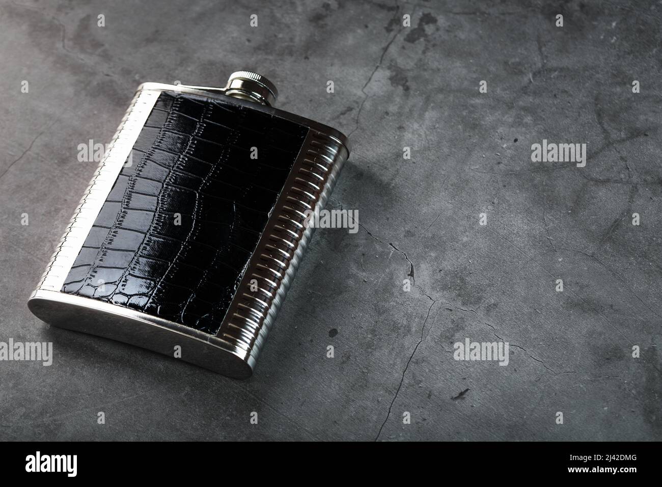 Pocket flask made of steel in leather finish with an alcoholic drink on ...
