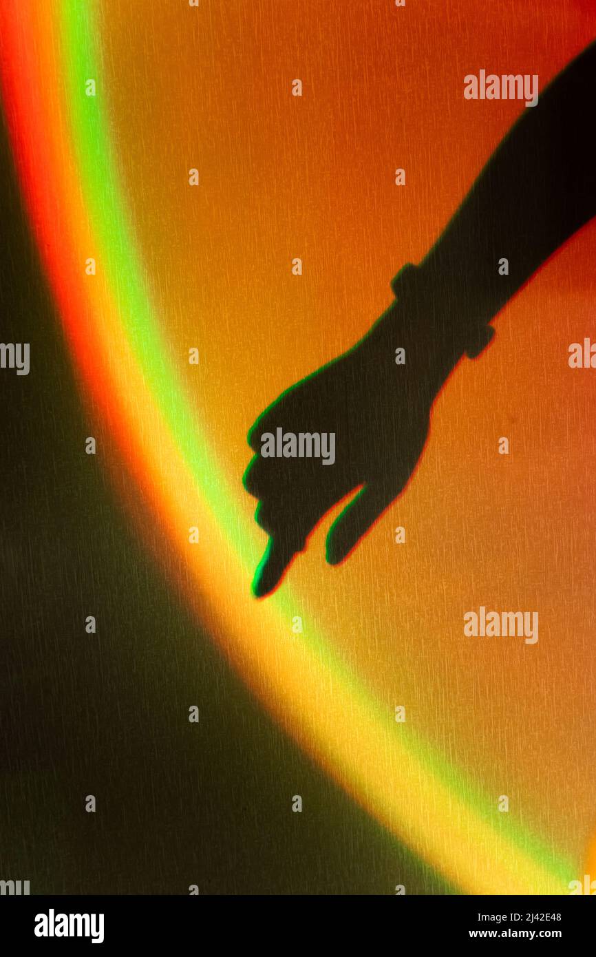 Shadow of womans hand. Rainbow reflection of sunbeam on wall. Hand ...