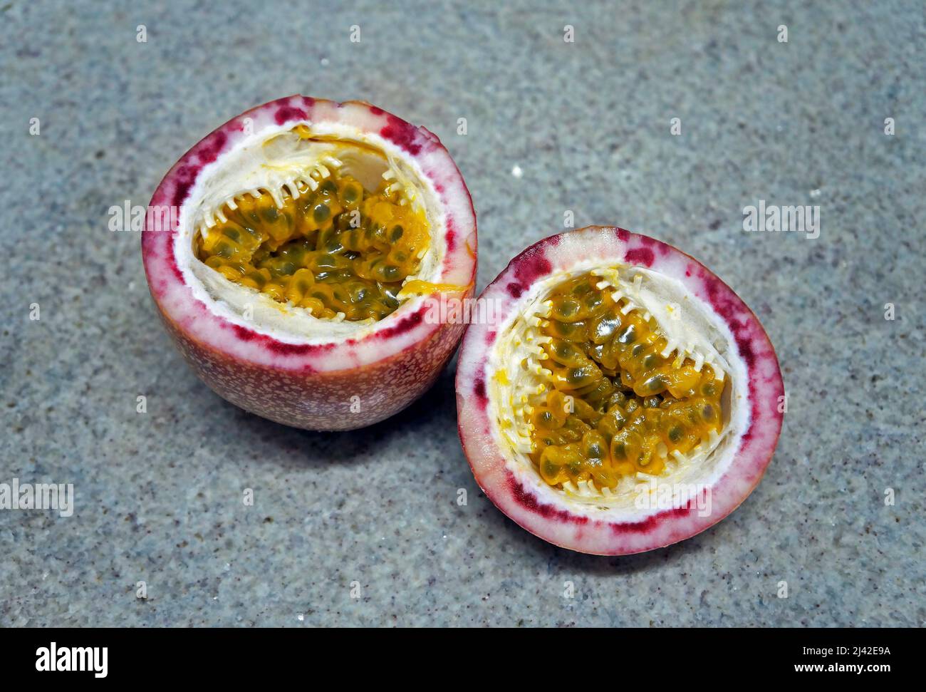 Sliced passion fruit in a granite background Stock Photo - Alamy
