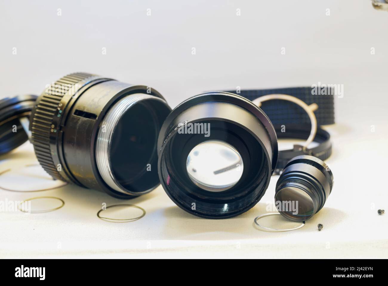 Clean and disassemble the lens for photography into its component parts ...