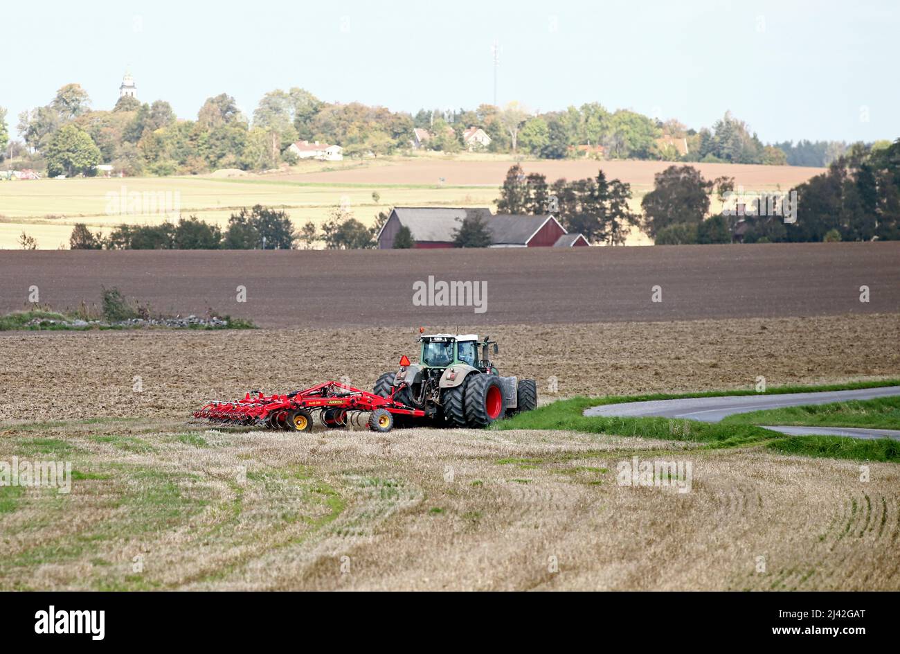 Tractor with harrow in a field in the countryside Stock Photo - Alamy