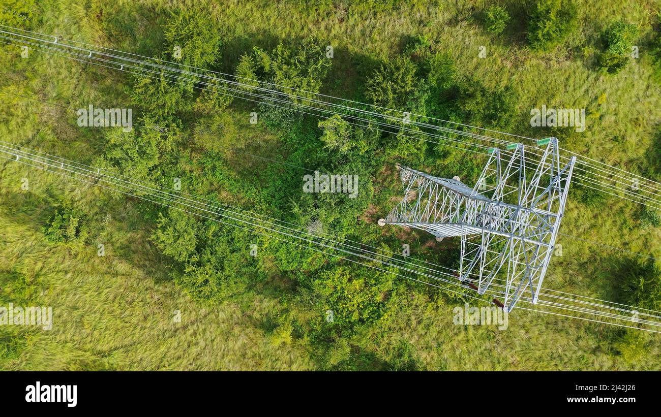 Aerial top down view high voltage steel power pylons in green field ...