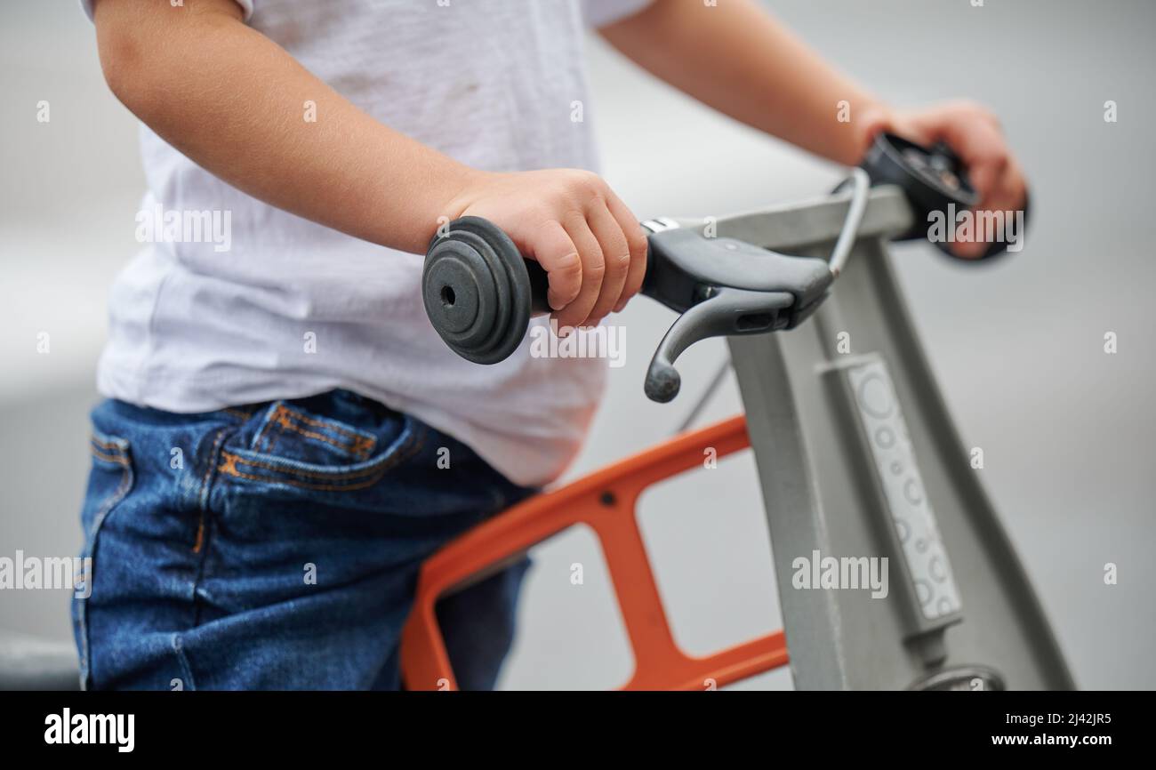 Close up view of child's hand holding bicycle handlebar while riding ...