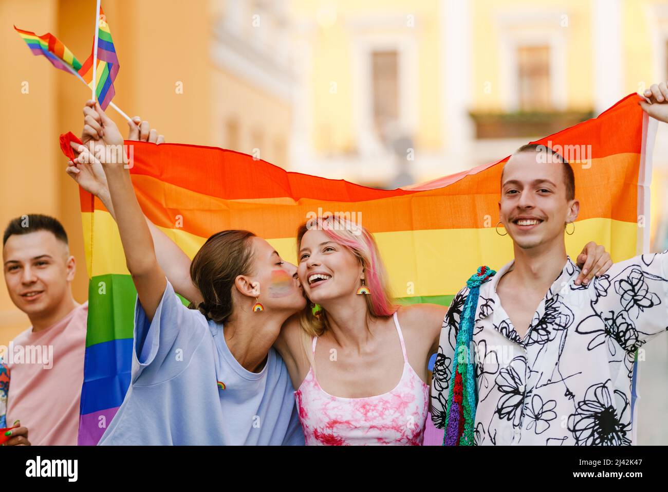 Multiracial men and women walking with rainbow flags during pride ...