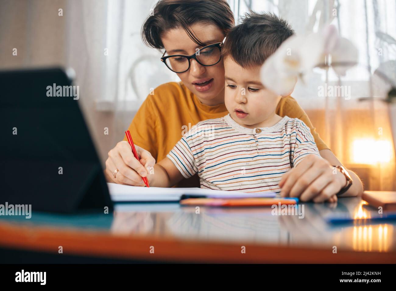 Caucasian mother, teaching her toddler boy writing the alphabet and ...