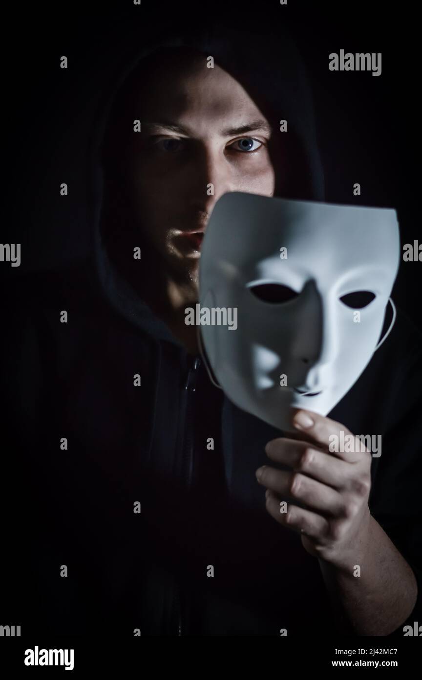 Take off the mask - Portrait of a young hooded man who takes off his ...