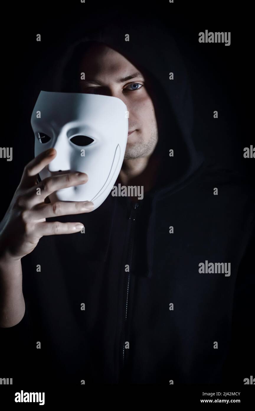 Portrait of a young hooded man taking off his mask, concept for being ...
