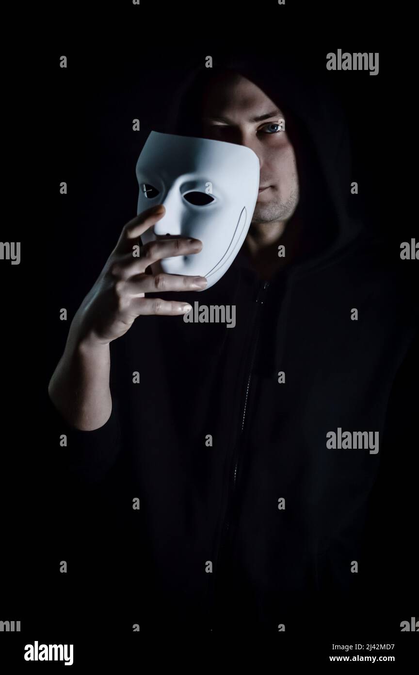 Portrait of a young hooded man taking off his mask, concept for being ...