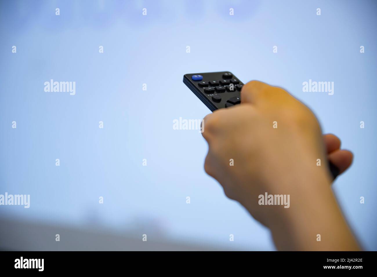 A remote controller with left hand behind the white board at the office ...