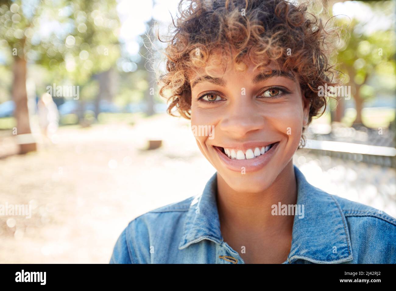 Smiles on a sunny day. Portrait of a beautiful young woman spending the ...