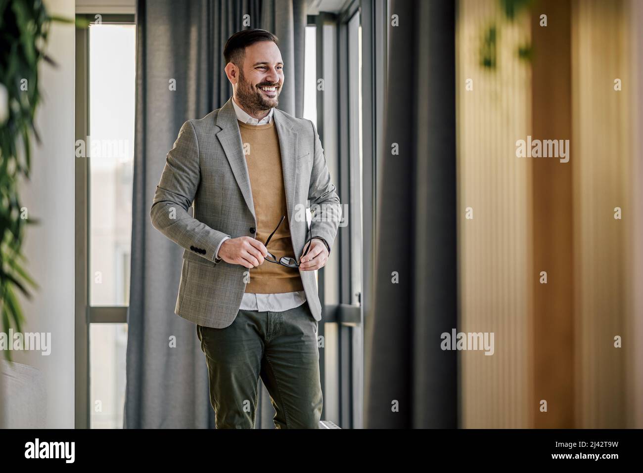 Laughing adult man, finishing with his work day, leaving the company ...