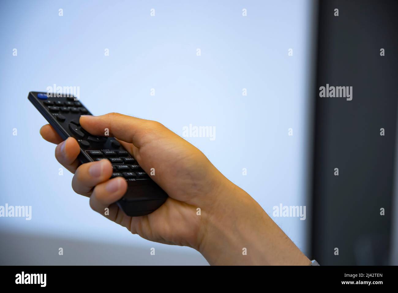 A remote controller with right hand behind the white board at the ...