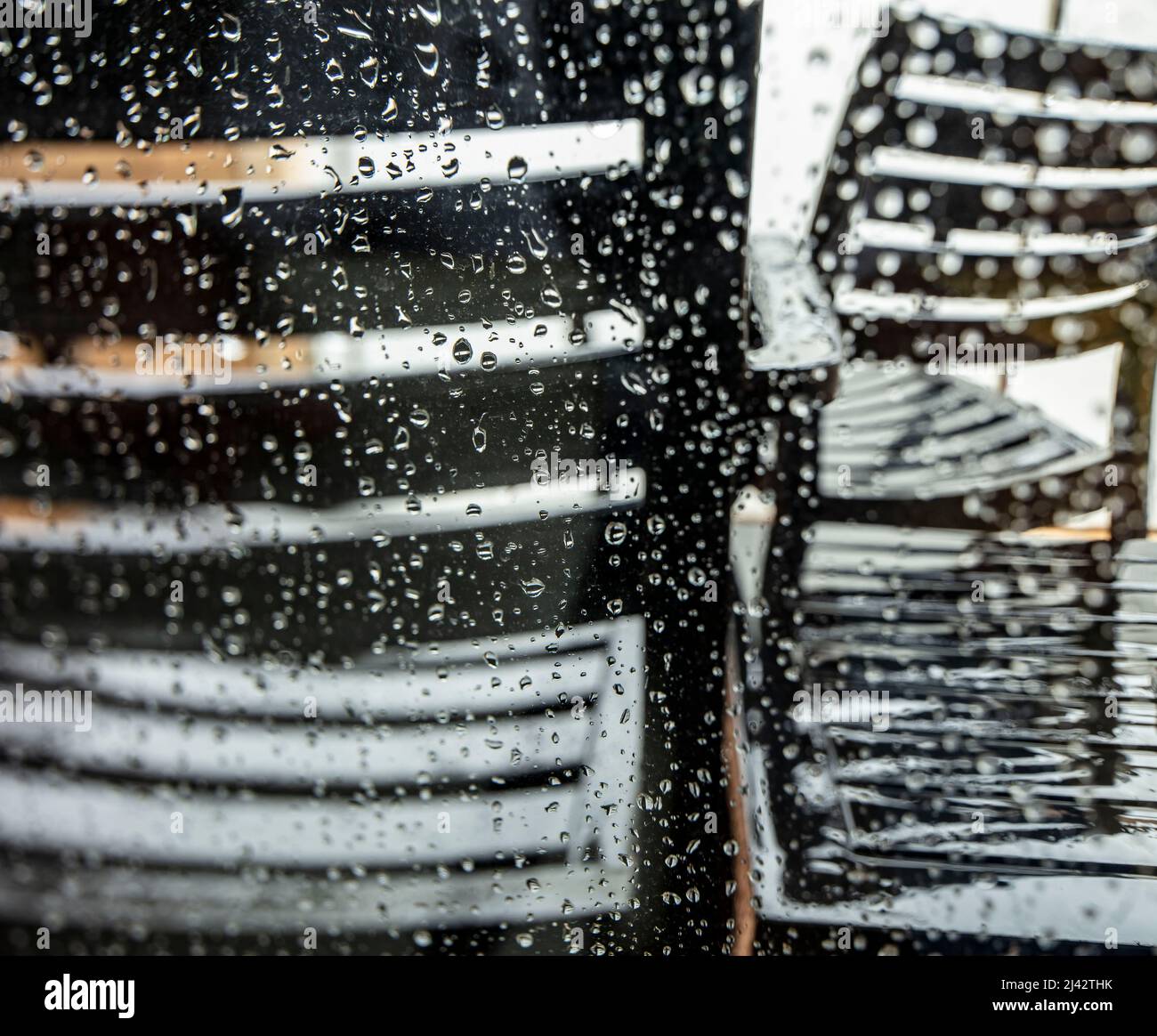 Semi-abstract still-life of rain on black plastic chair, Benidorm ...