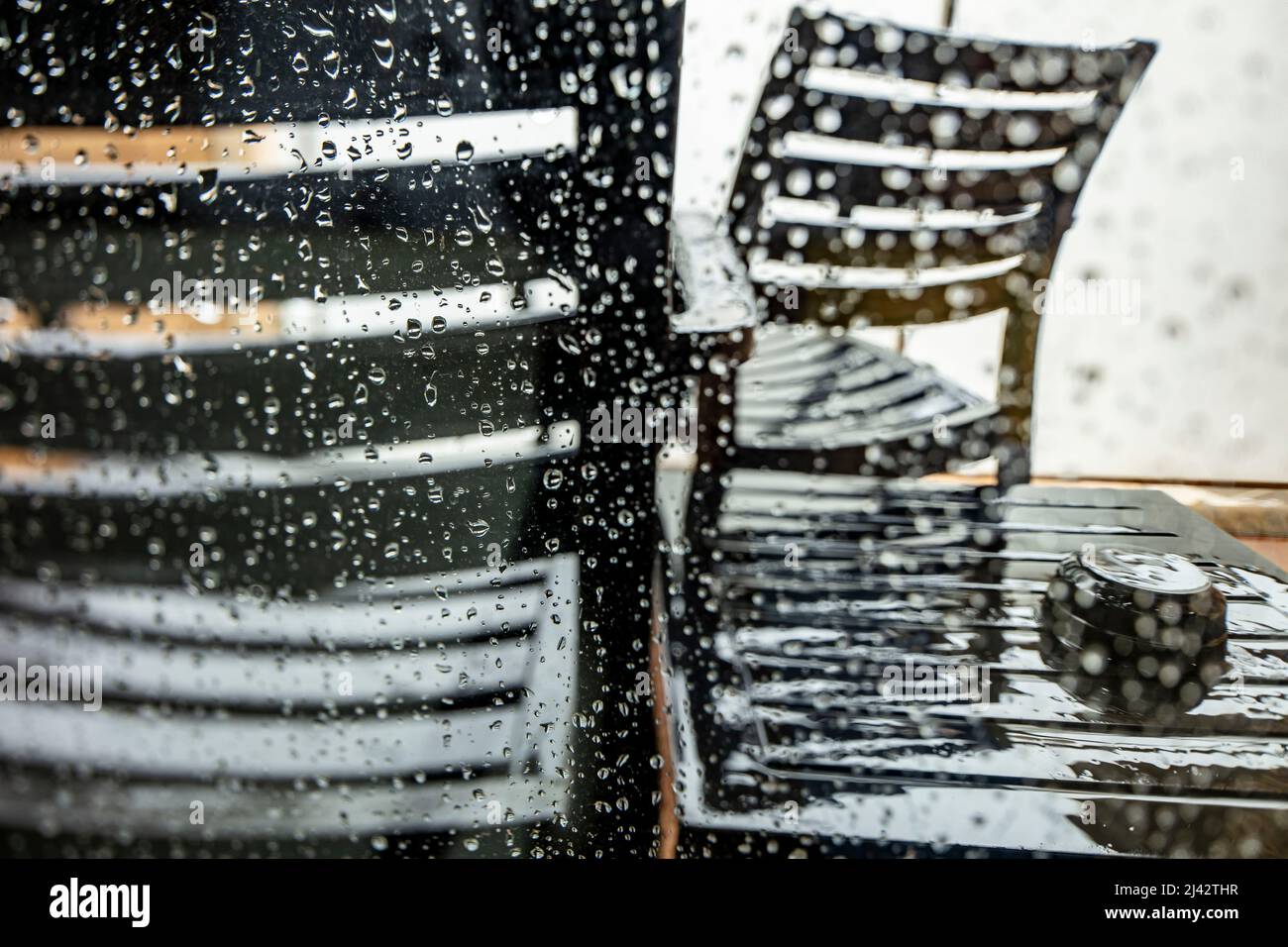 Semi-abstract still-life of rain on black plastic chair, Benidorm ...