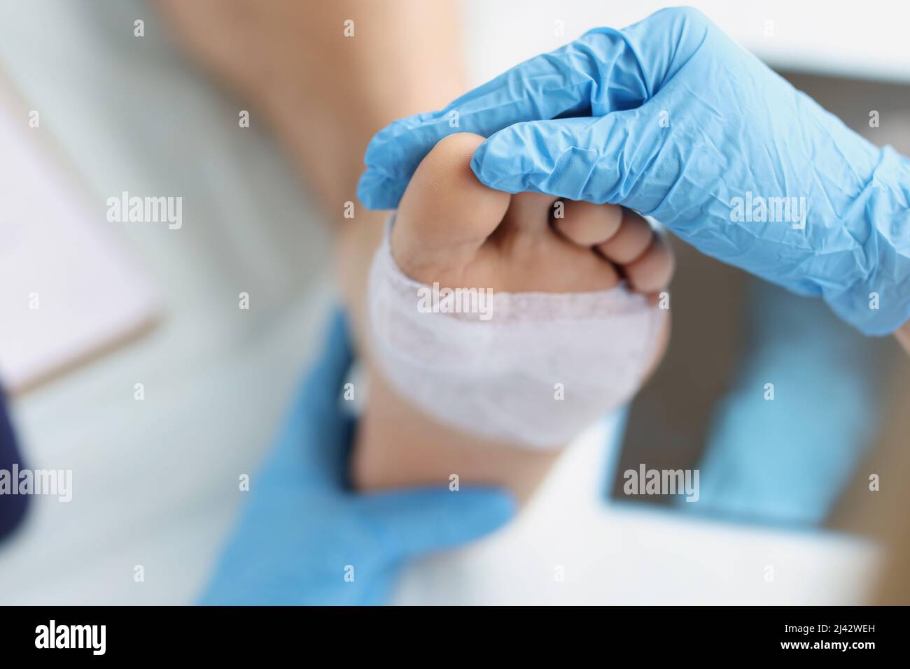 Doctor conducts medical examination of foot with patch Stock Photo - Alamy