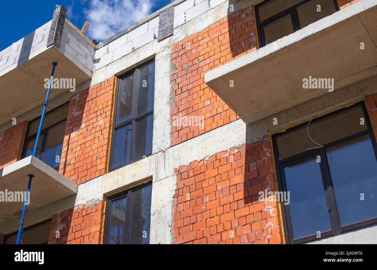 Red brick apartment building facade block with panoramic windows under ...
