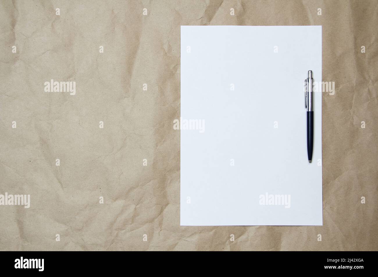 White empty sheet of A4 format with pen on a beige craft paper. Concept ...