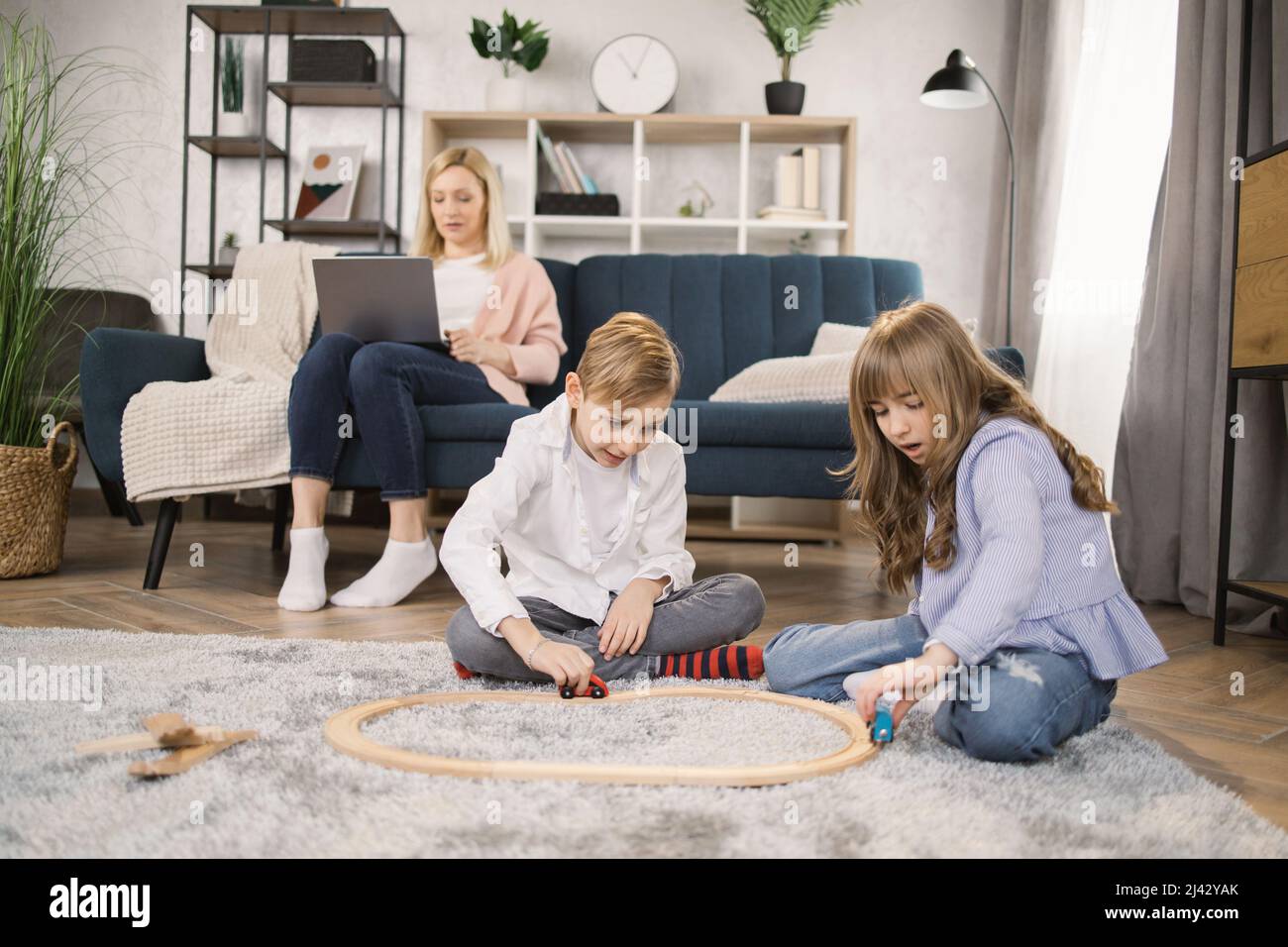 Cute little preschooler boy and girl siblings sit on warm floor play at ...