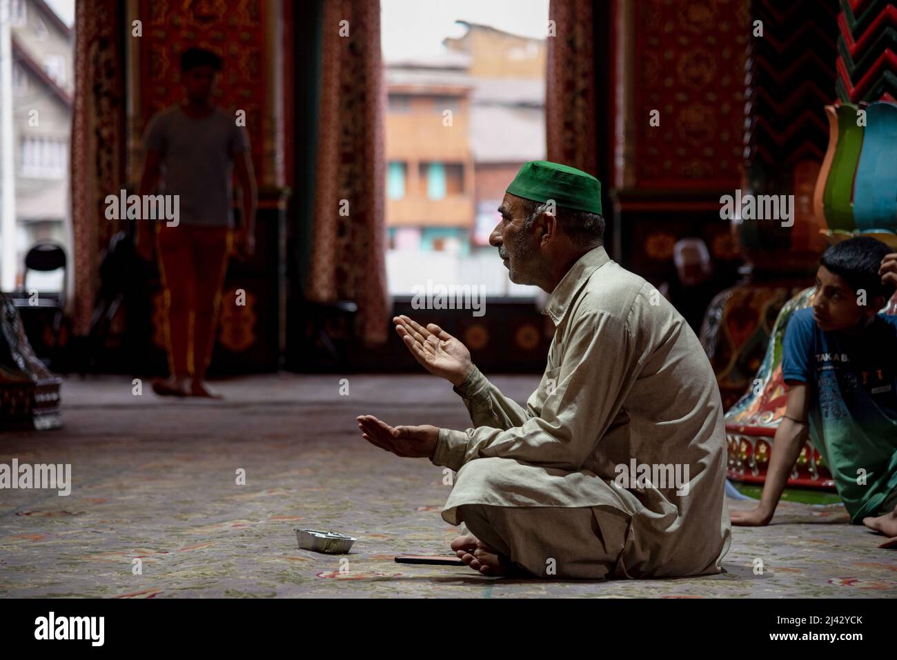 A Muslim devotee prays inside a shrine during Islamic holy month ...