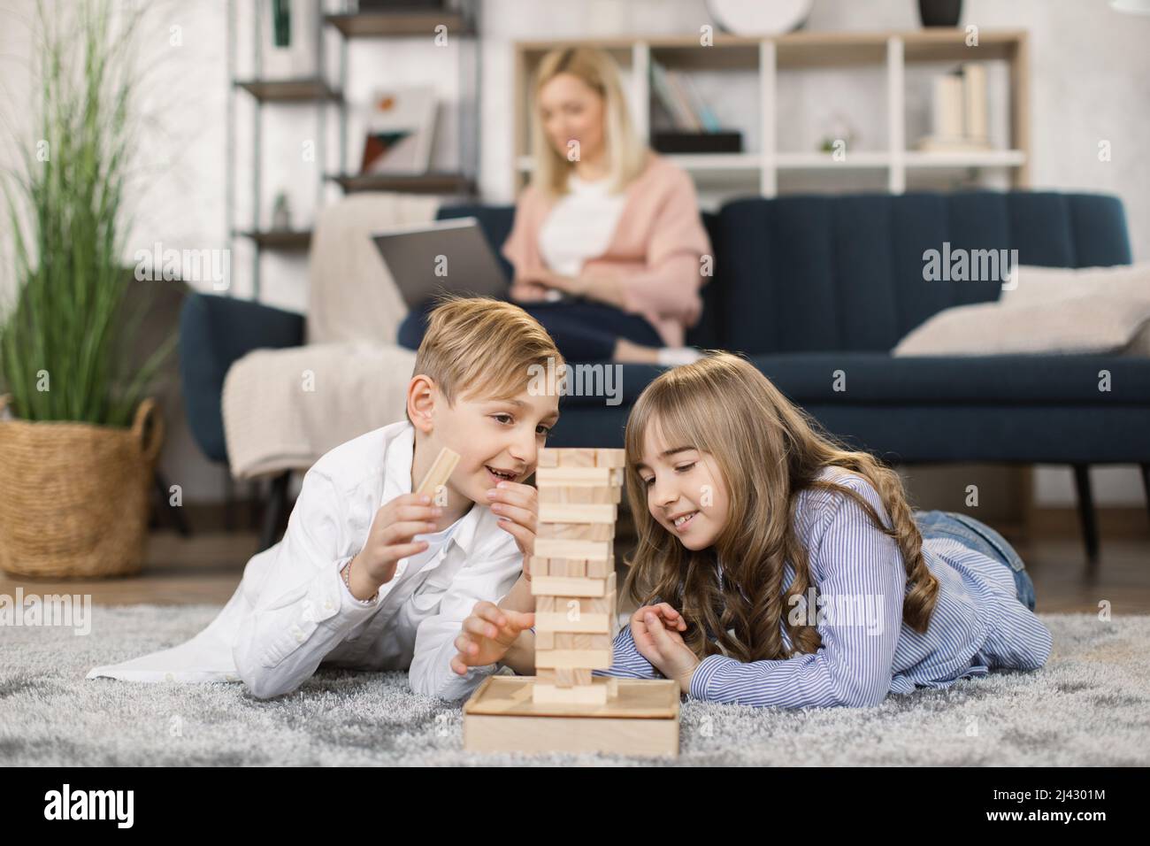 Little children sit on warm floor in living room play construct with ...