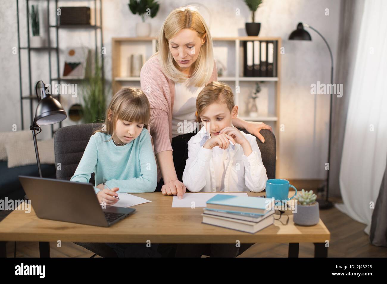 Dughter and son doing school lessons together looking at a laptop ...