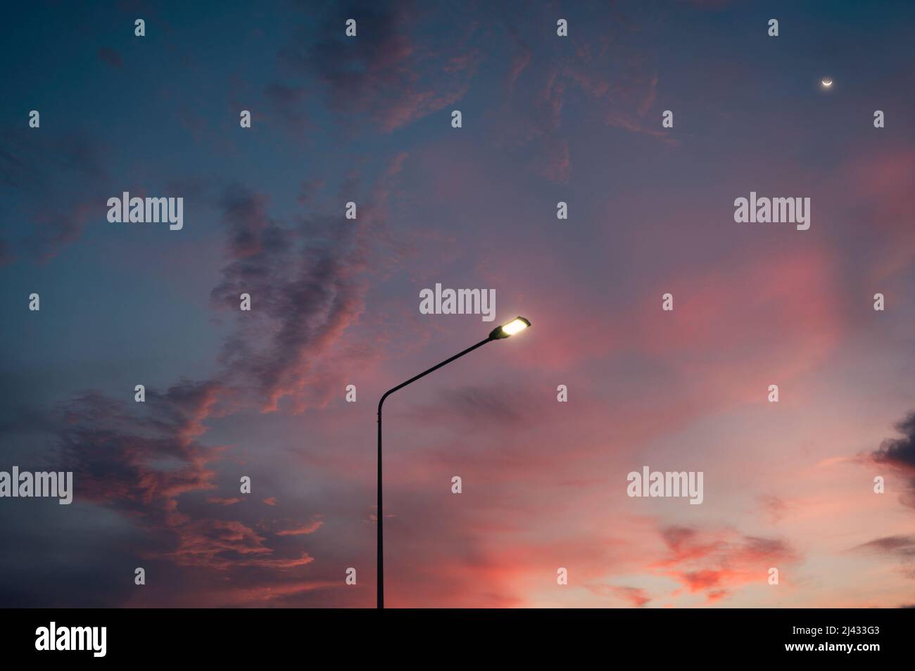 Street light pole with the moon and colorful evening sky Stock Photo ...