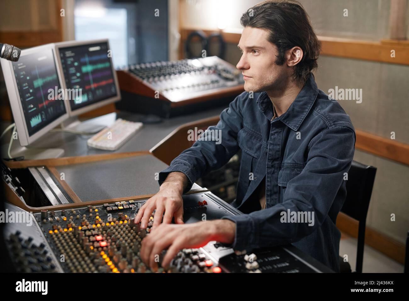 Portrait of male music producer using digital audio workstation while ...